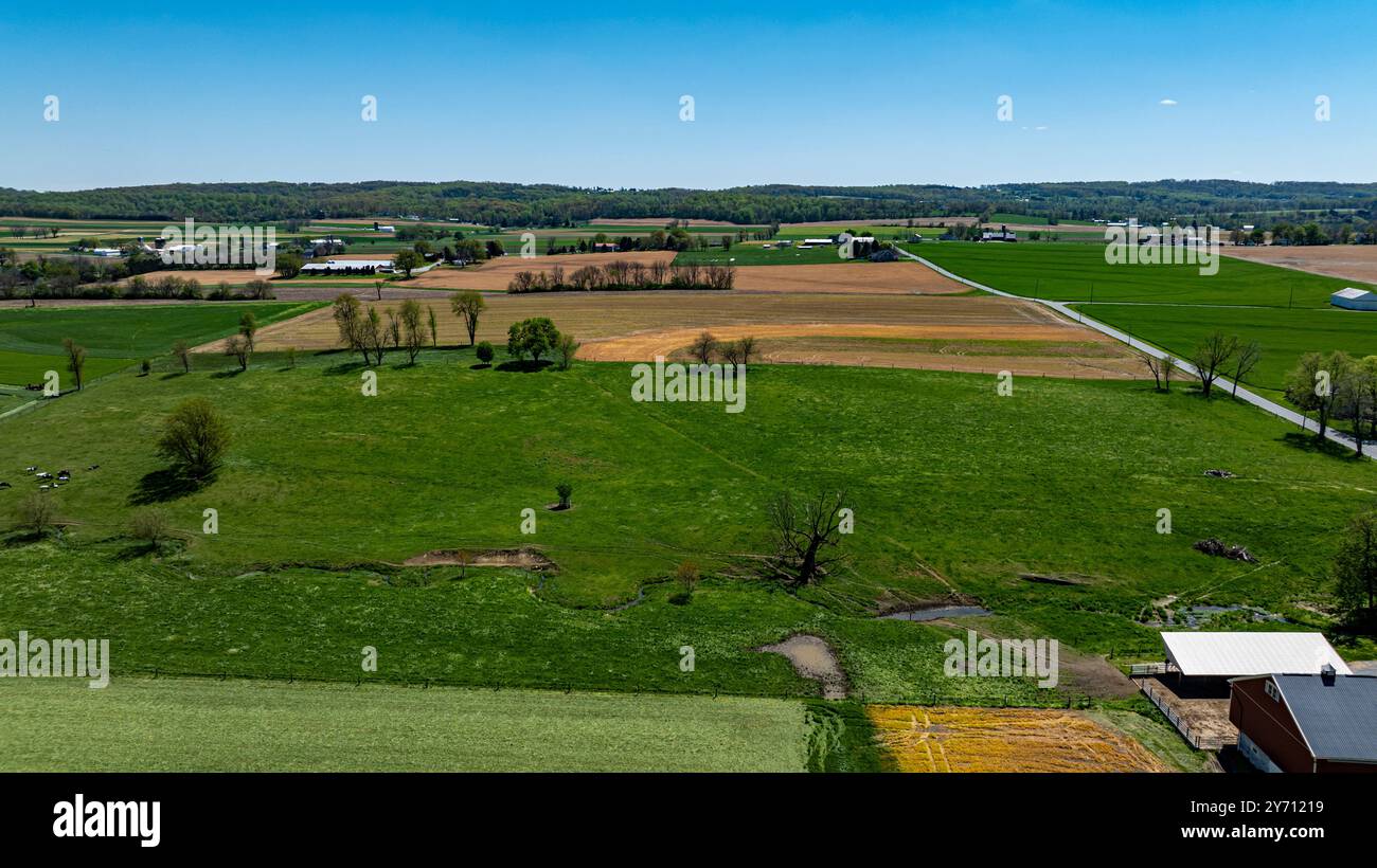 The expansive view shows verdant fields dotted with patches of brown ...