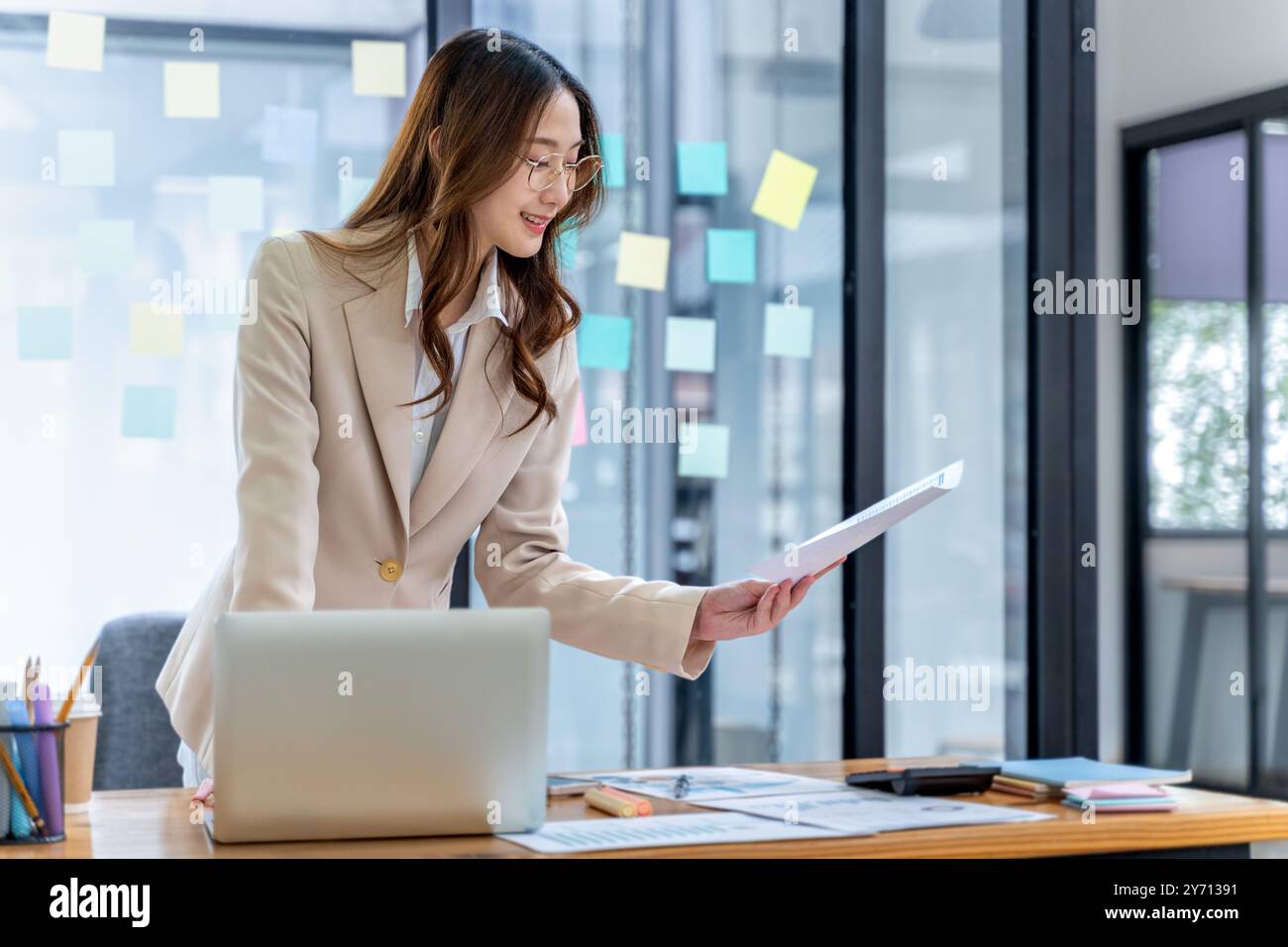 Happy young business woman working on her project at the office alone ...