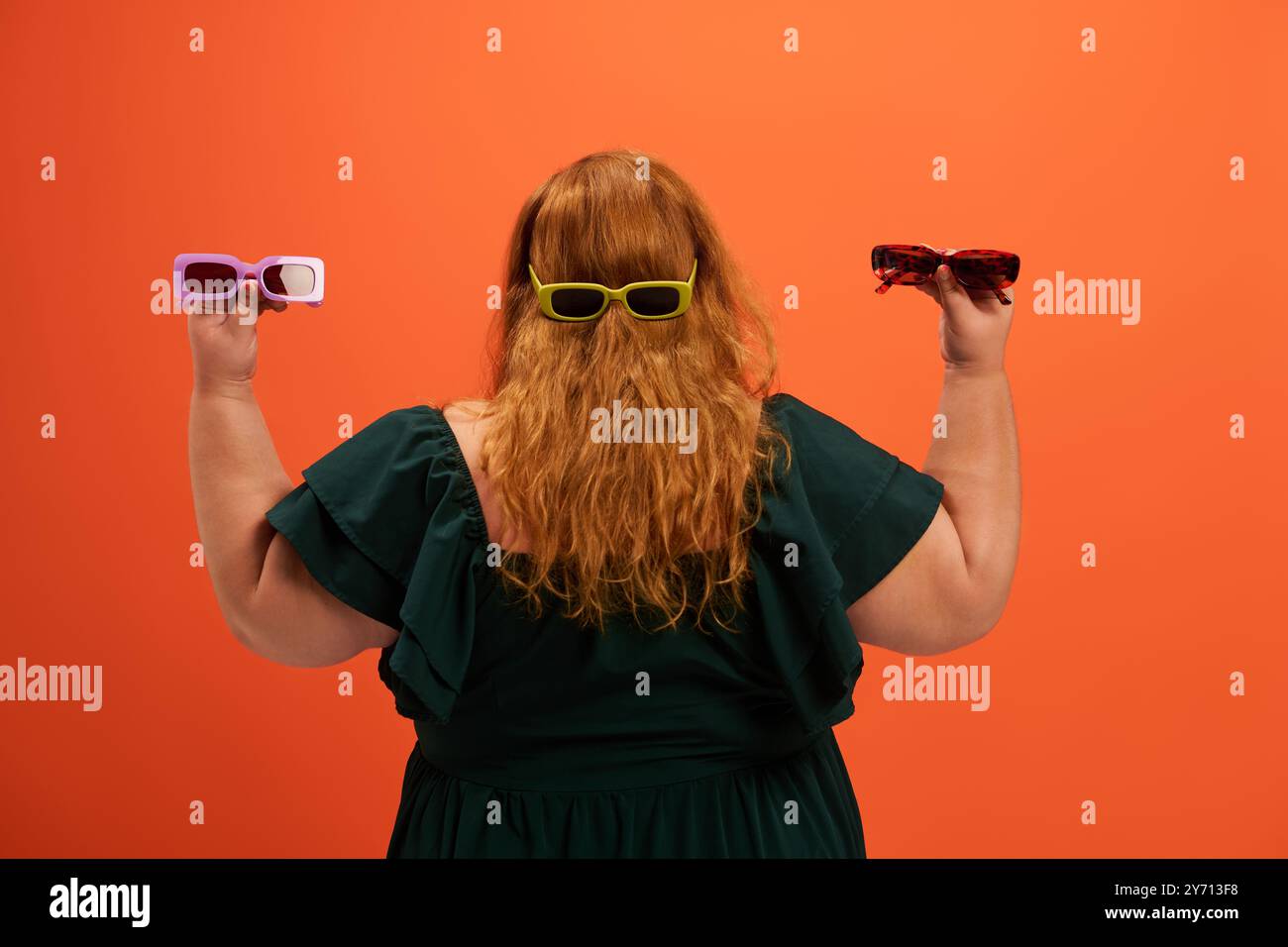 A confident plus size woman poses with colorful sunglasses, radiating ...