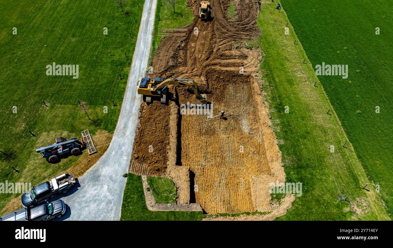 An excavator is digging into the ground to prepare a foundation for ...