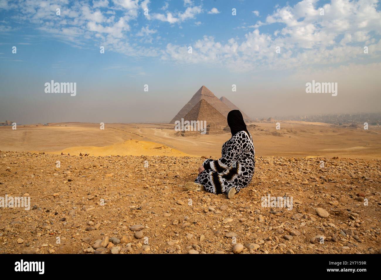 Back view of a woman in a long traditional Muslim dress looking at the ...