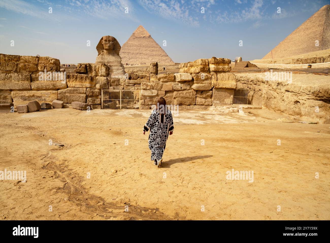 Back view of a woman in a long traditional Muslim dress looking at the ...