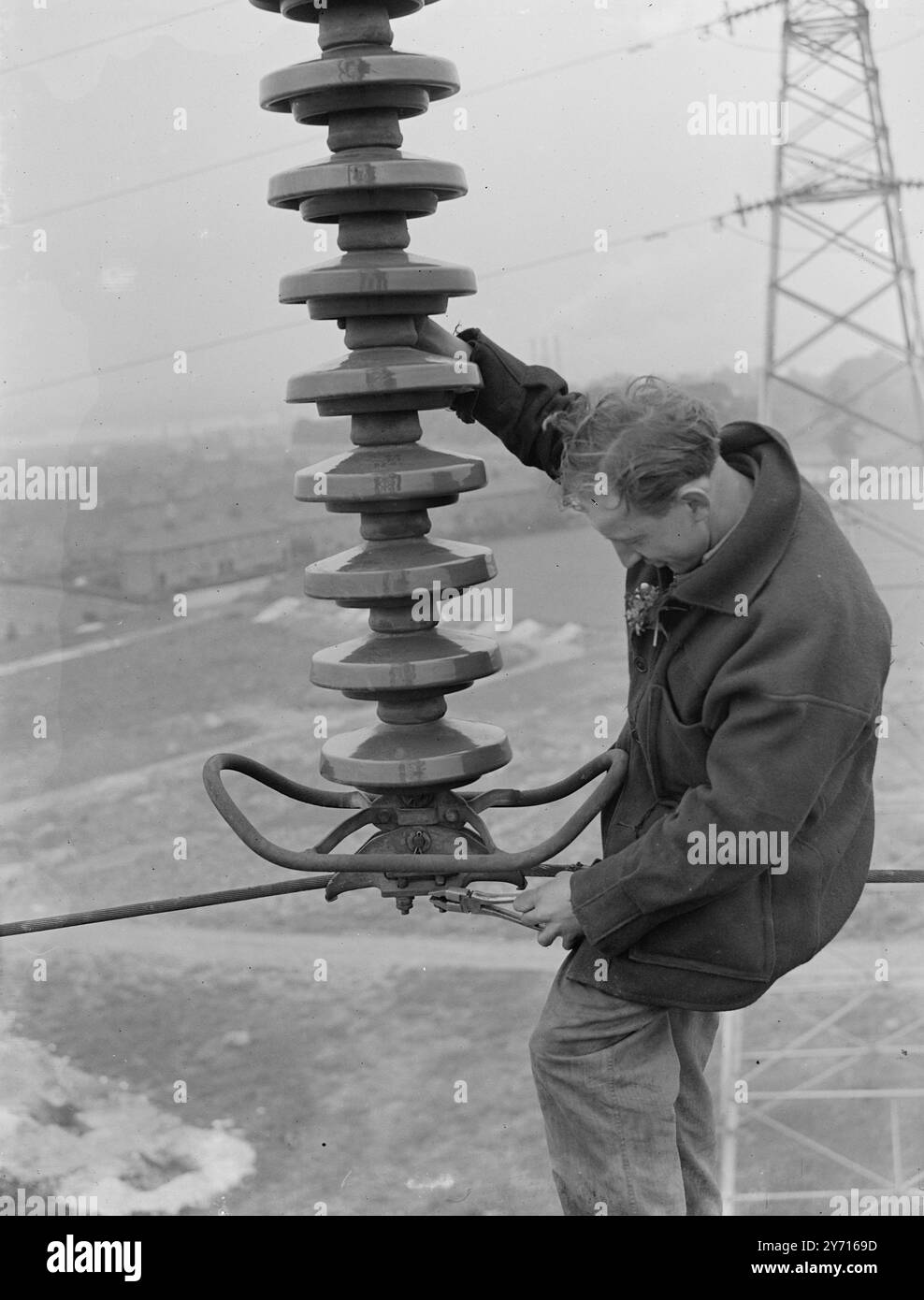 Electric Grid cleaning - man sitting on wire 1 January 1946 Stock Photo ...