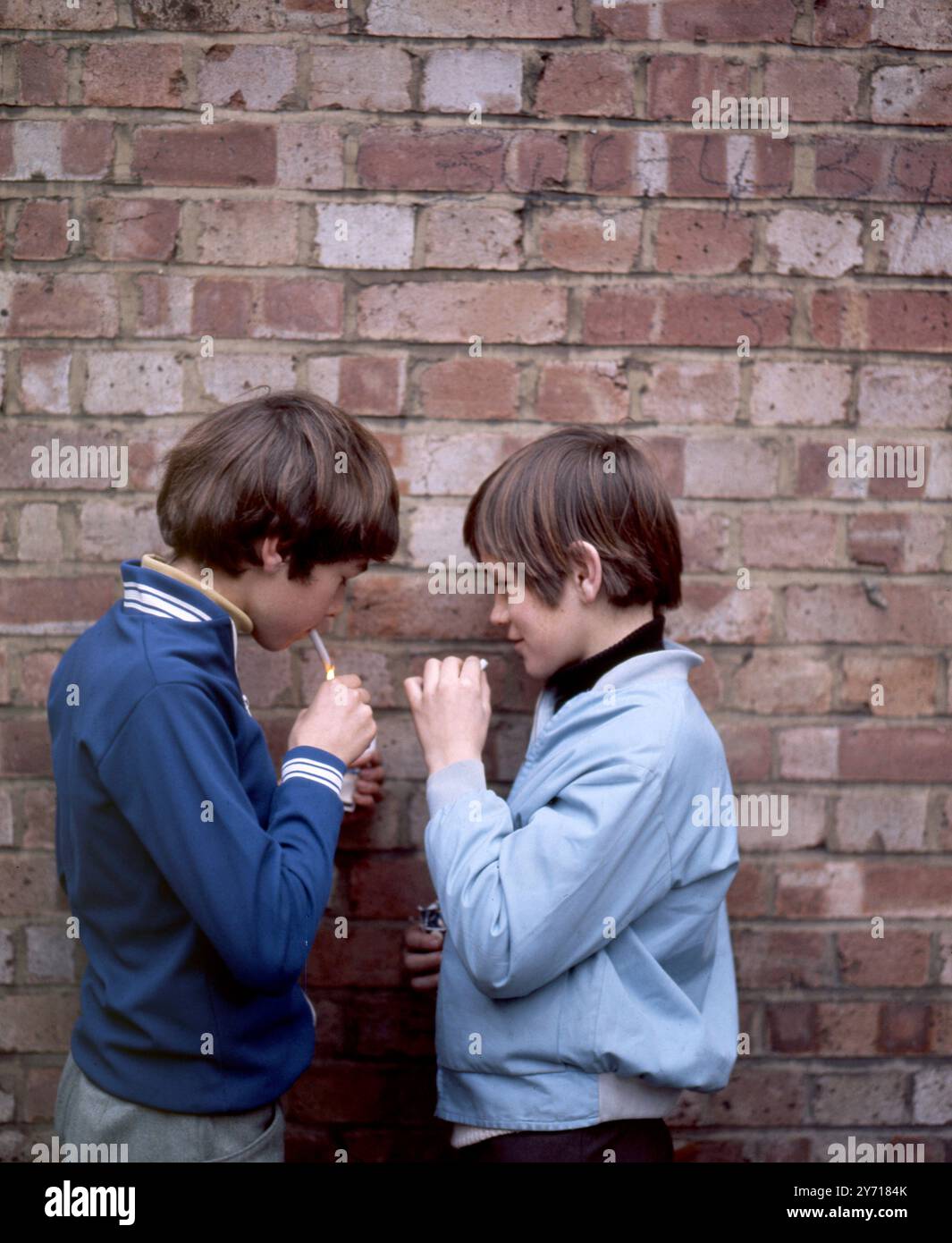Two young boys smoking behind the bike shed 1970's Stock Photo - Alamy