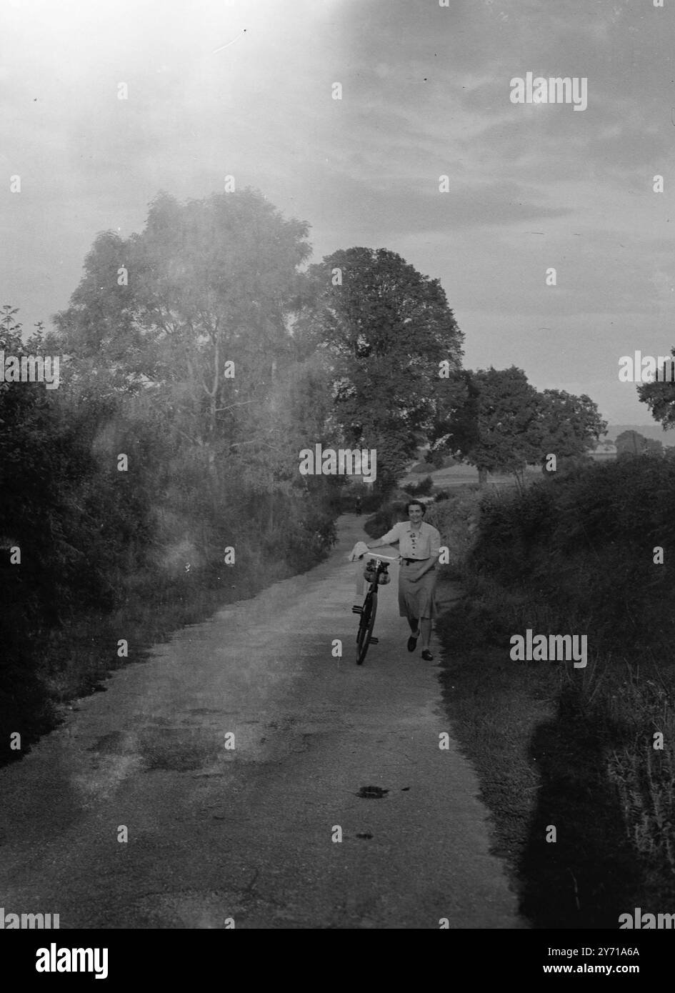 Road Scene woman with bike shadow of photographer RHS 1946 Stock Photo ...