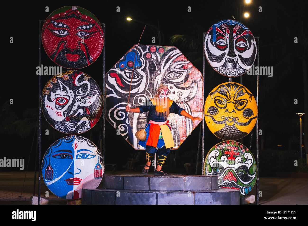 A male asian actor in a costume and mask arranges a performance at an ...
