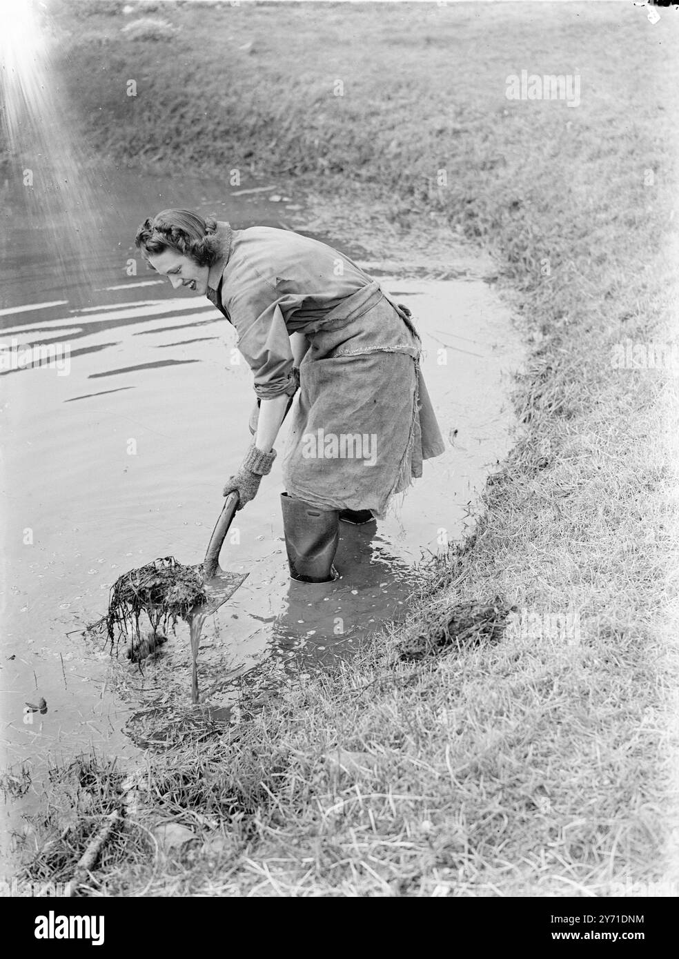 Land girl digging mud c. 1940 Stock Photo - Alamy