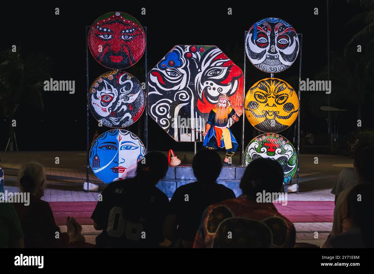 A male asian actor in a costume and mask arranges a performance at an ...