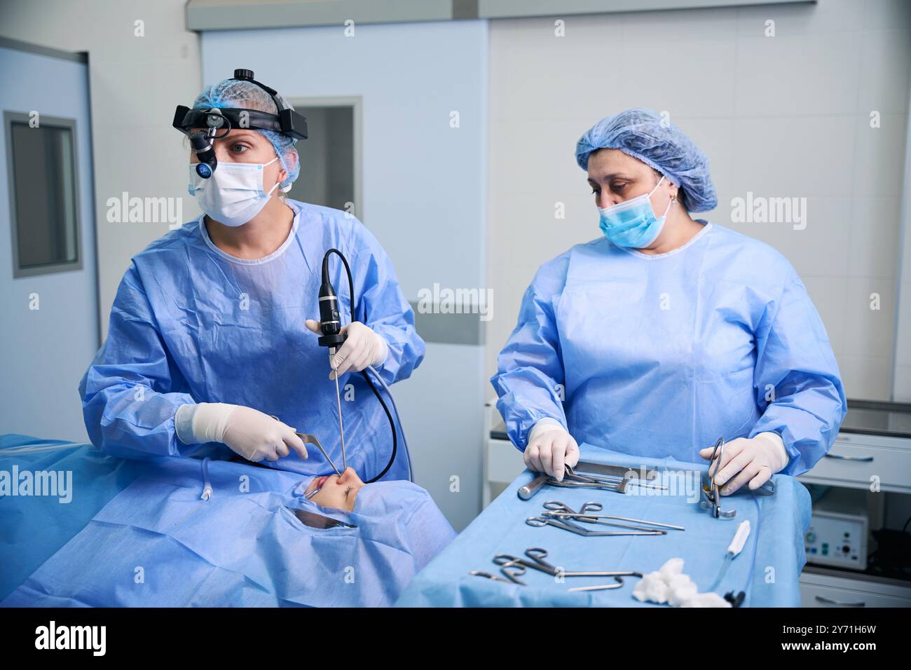 Surgeon with assistant working in sterile operating room using modern ...
