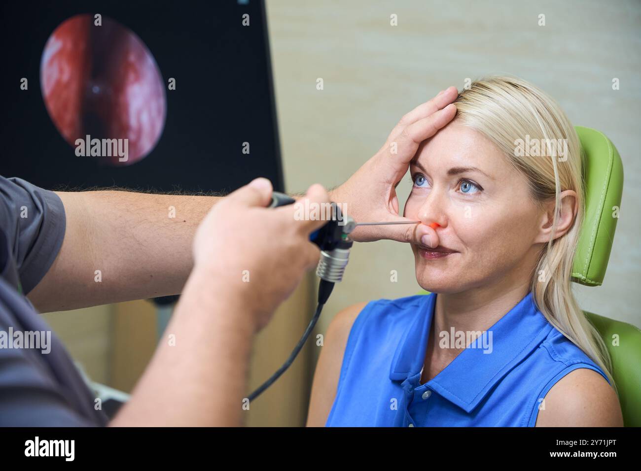 Doctor performing nose check-up, patient seated Stock Photo - Alamy