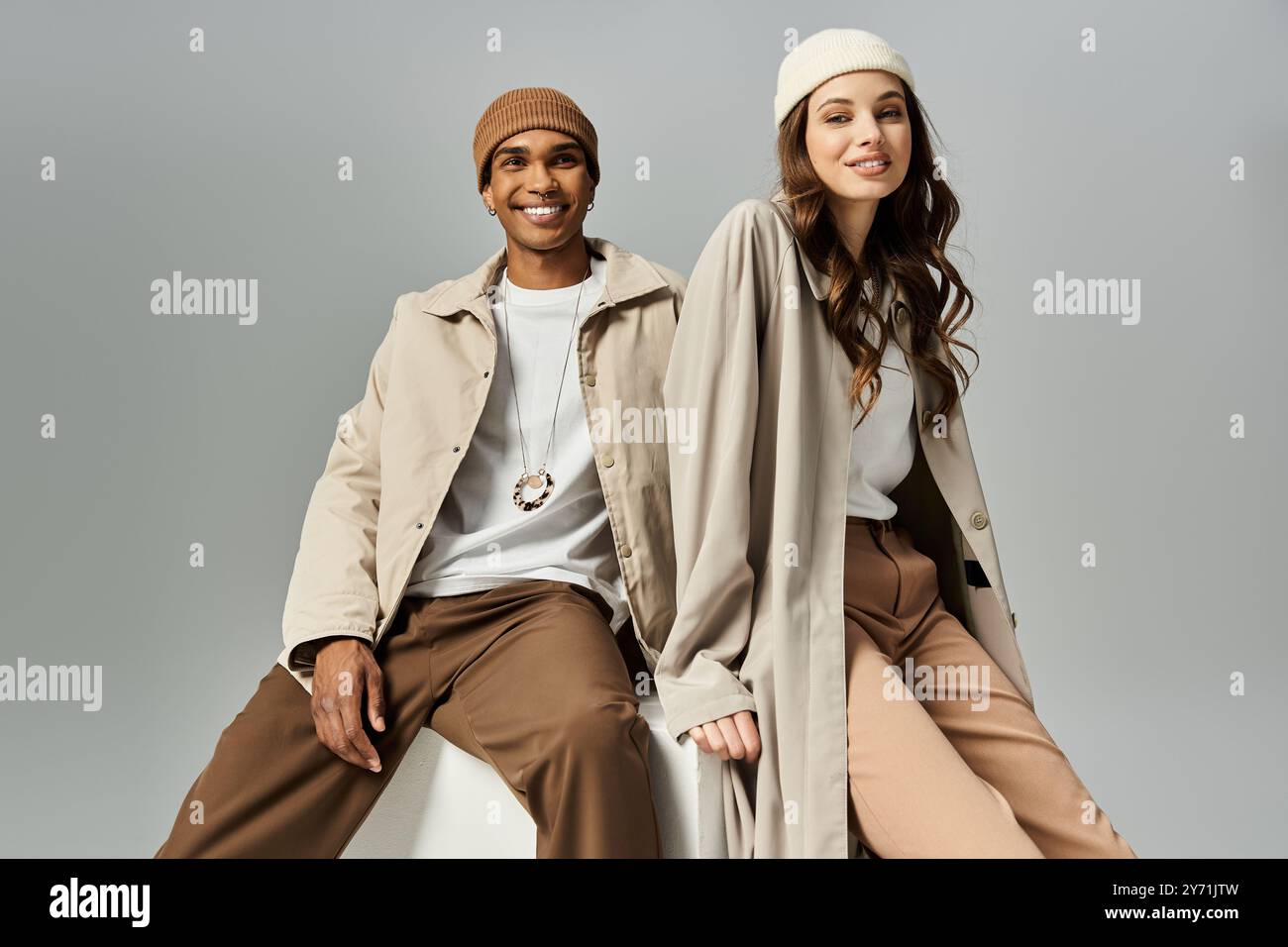 A trendy couple enjoys a playful moment wearing colorful autumn outfits ...