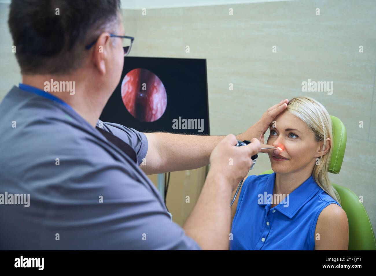 Doctor examining patients nose with otoscope Stock Photo - Alamy