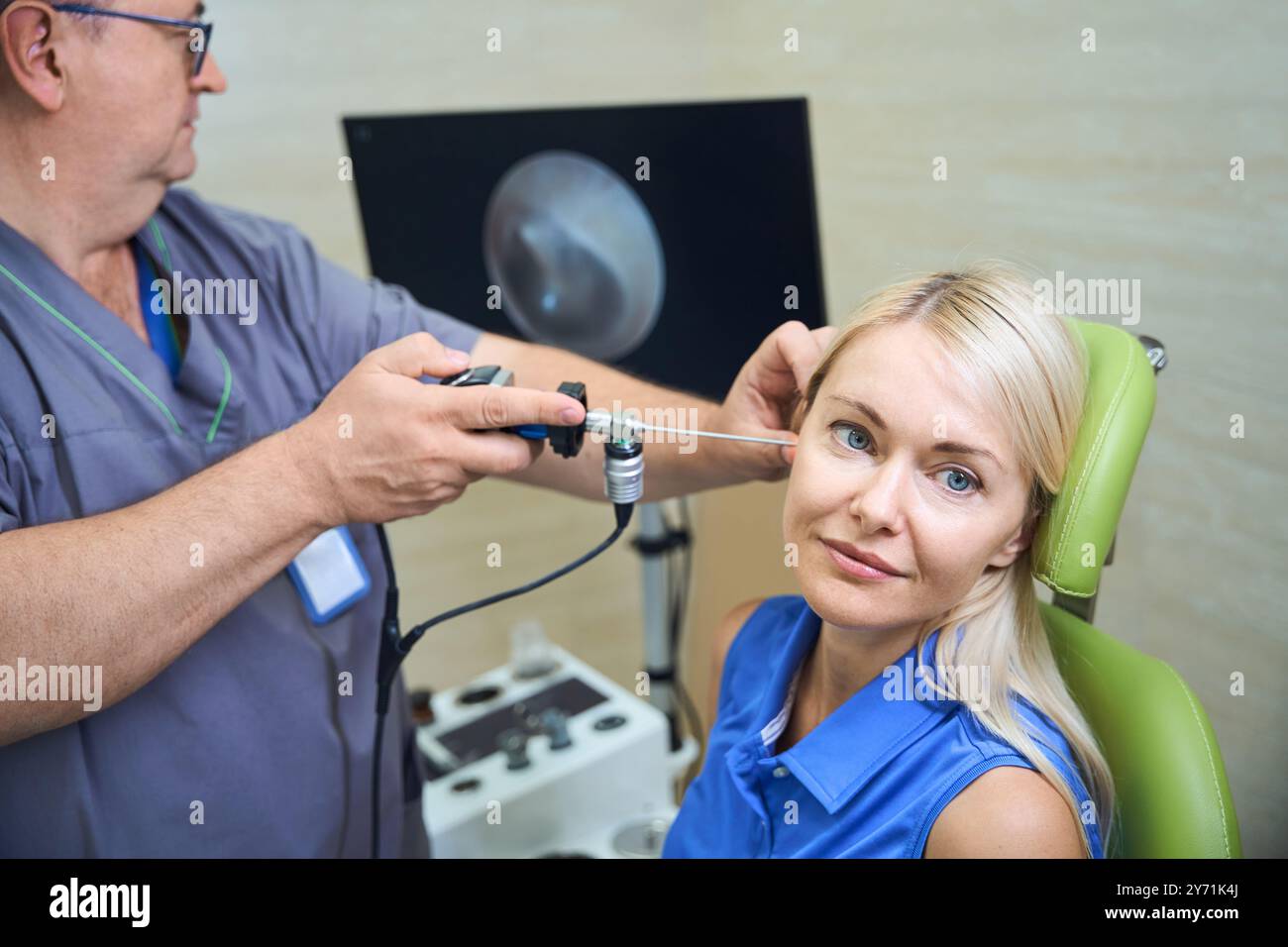 Doctor performing detailed ear examination, patient calm Stock Photo ...