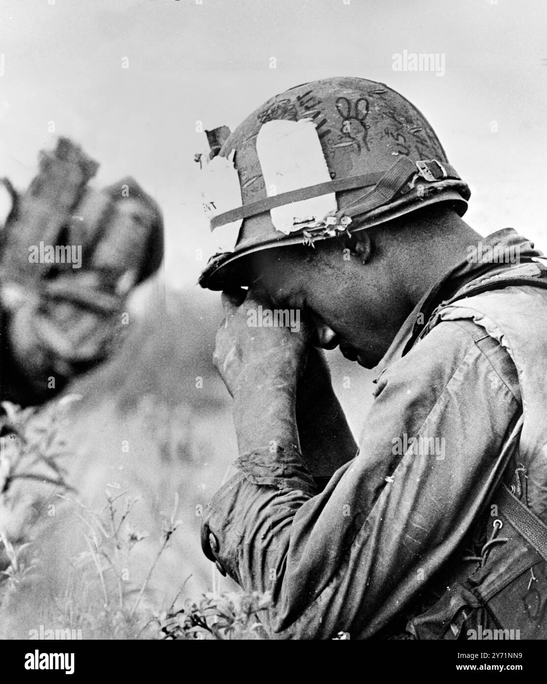 A weary GI rests for a moment as the war goes on around him in Ben Loc ...