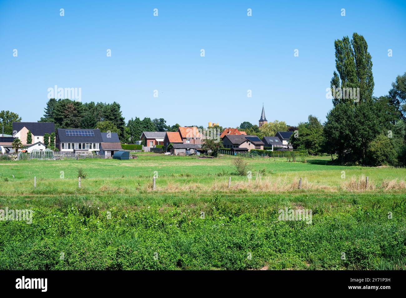Green meadow and house backyards at the Flemish countryside in Halen ...