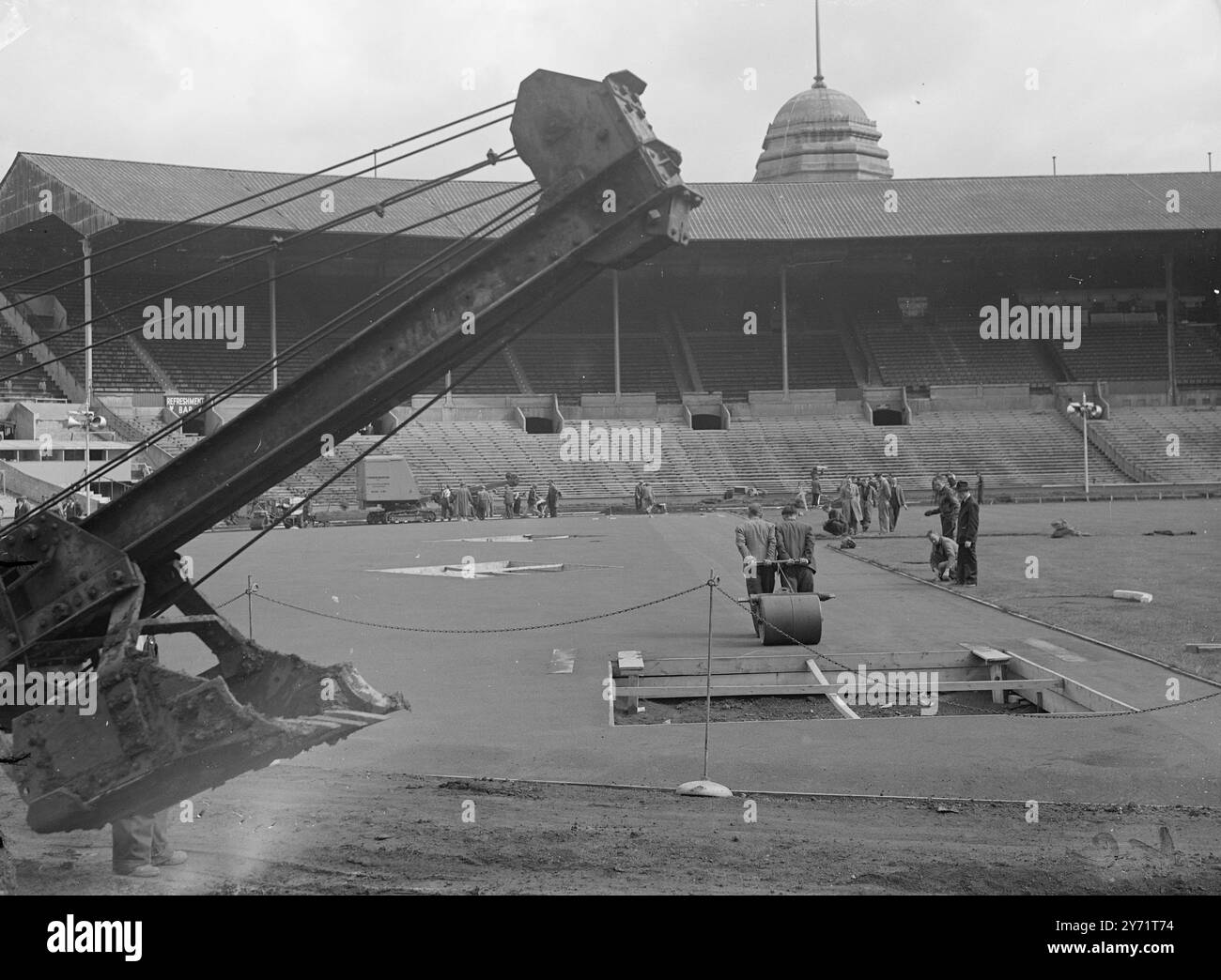 "Pre-Olympic Scene" A heavy crane and rollers are being used to prepare ...
