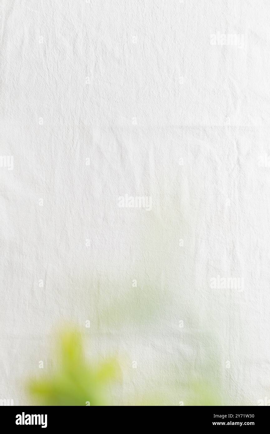 Fine bright linen cloth with green leaves. The tablecloth on top view ...