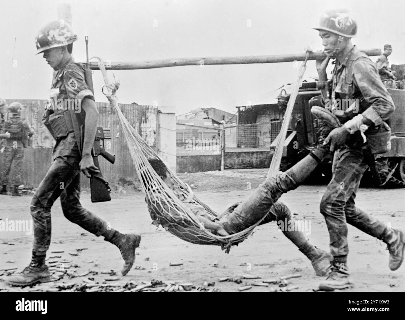 Saigon: Vietnamese soldiers carry a wounded comrade in a hammock-like ...