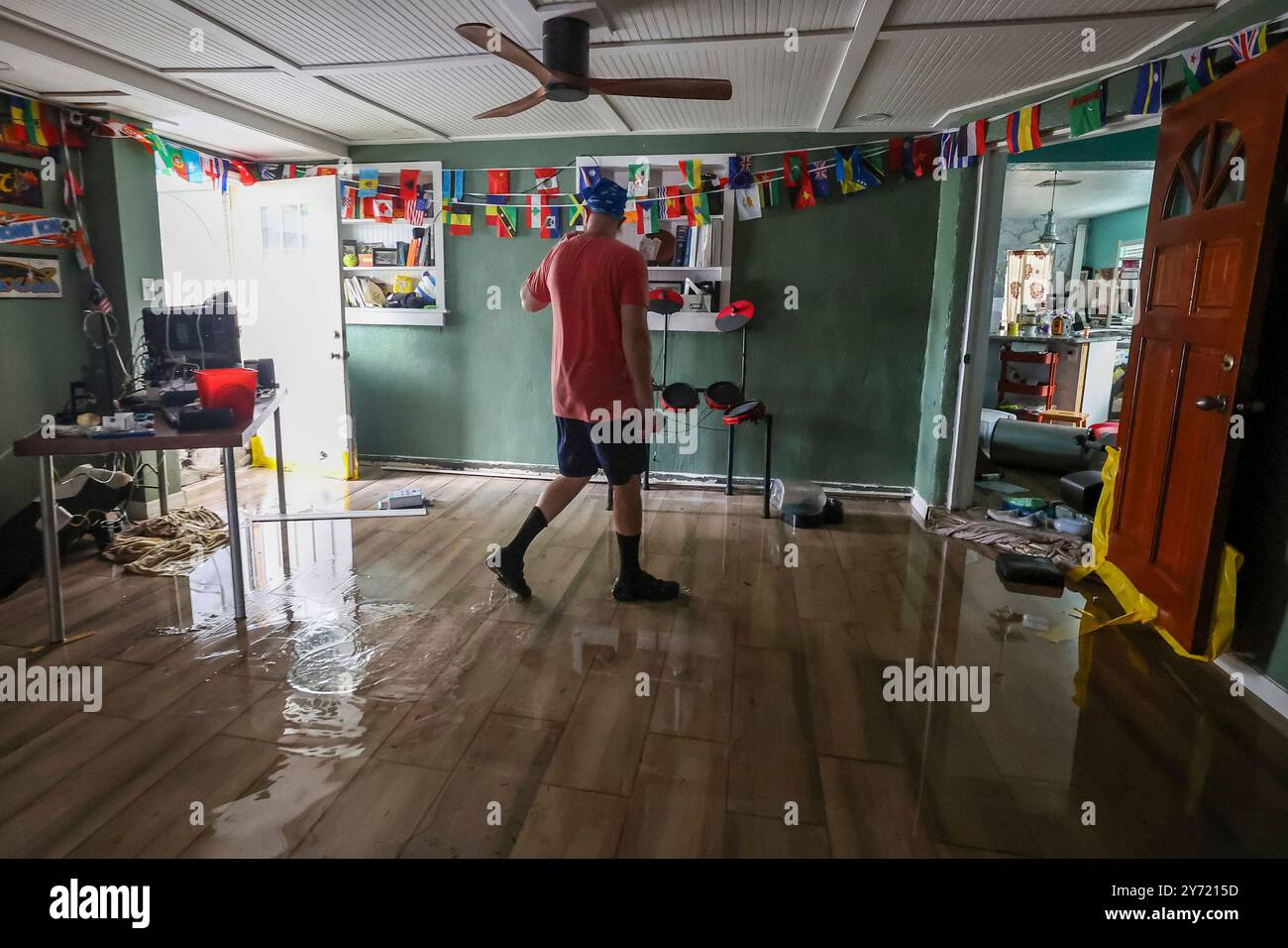 Bradley Tennant looks through his house flooded with water from ...