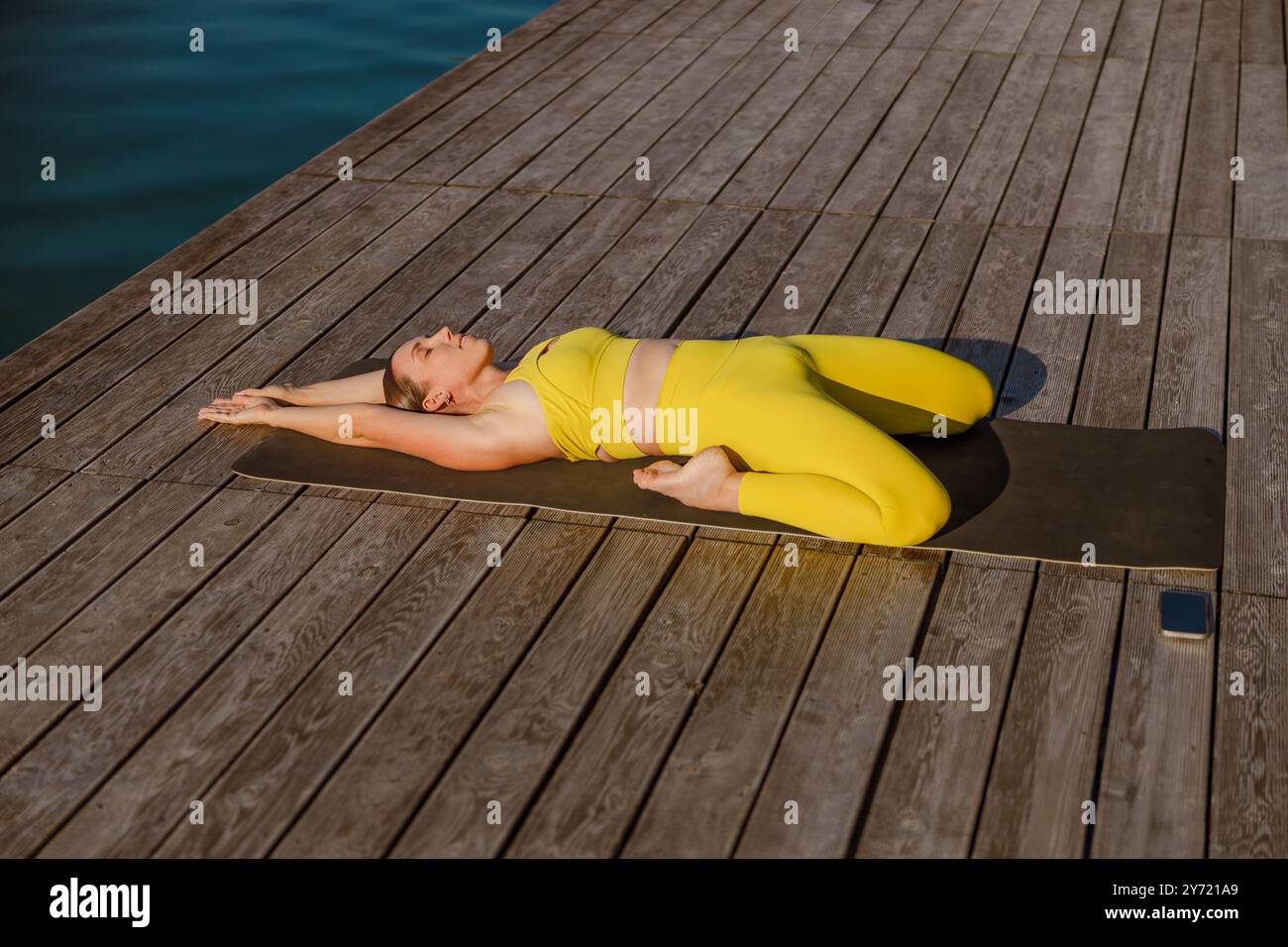 Engaging in a Yoga Pose on the Dock Enjoy a Serene and Invigorating ...