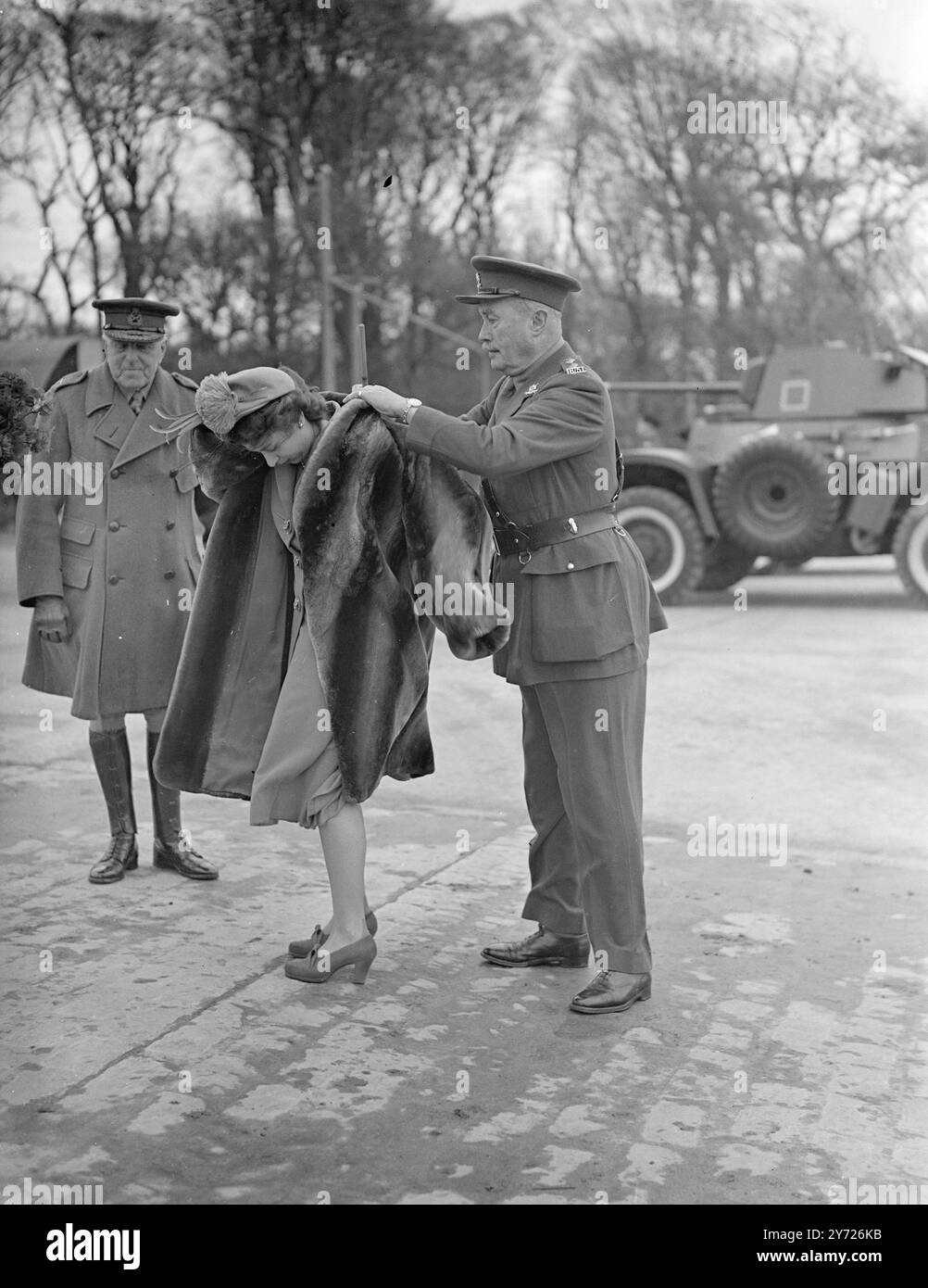 Her Royal Highness Princess Elizabeth is helped on with her fur coat by ...