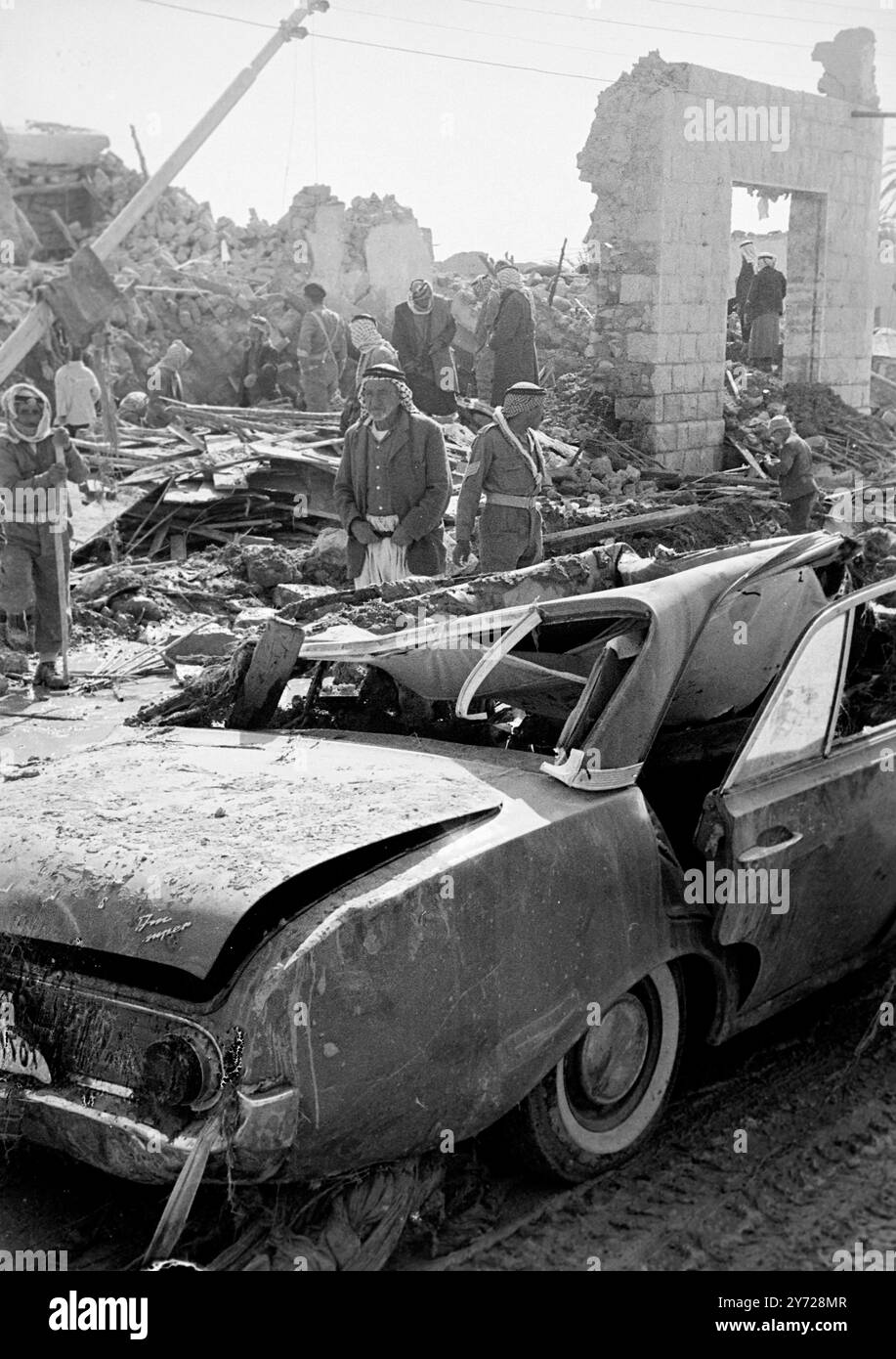 A crumpled car stands in place it was parked outside a stone building ...