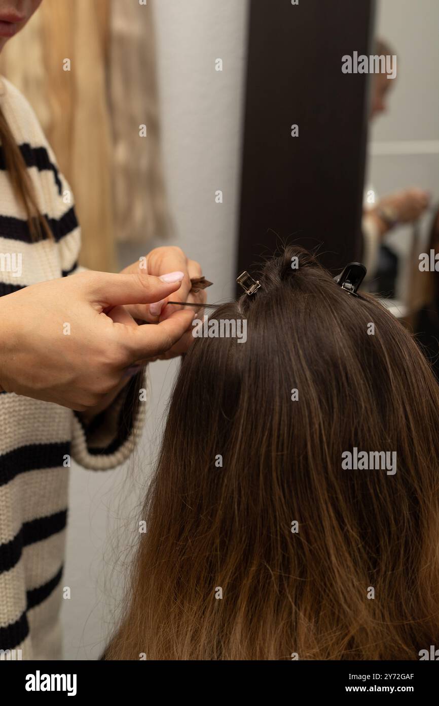 The process of hair extensions. Hair encapsulation. Beauty parlour ...