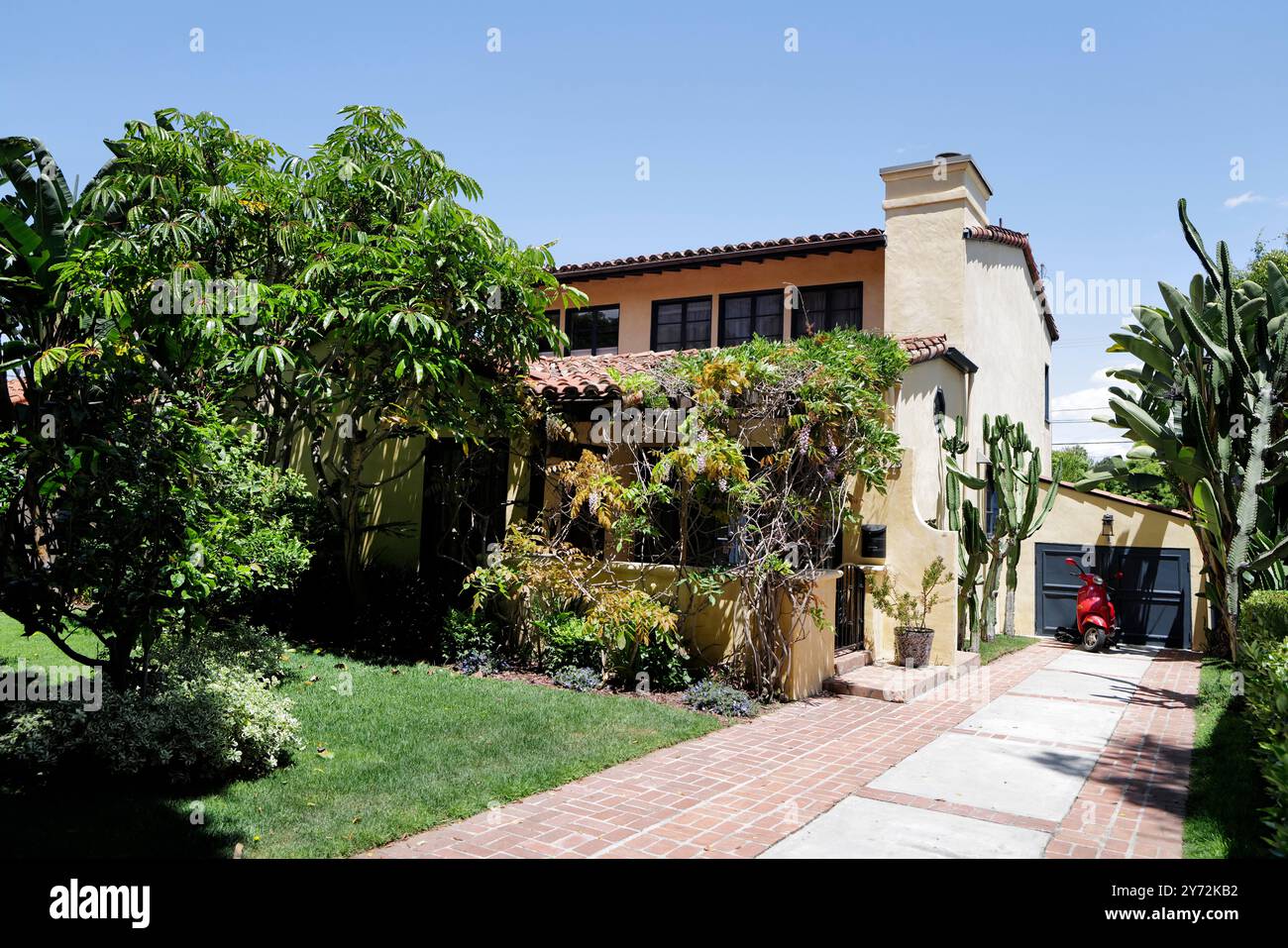 Charming Spanish-style house with lush garden, featuring tall palm ...