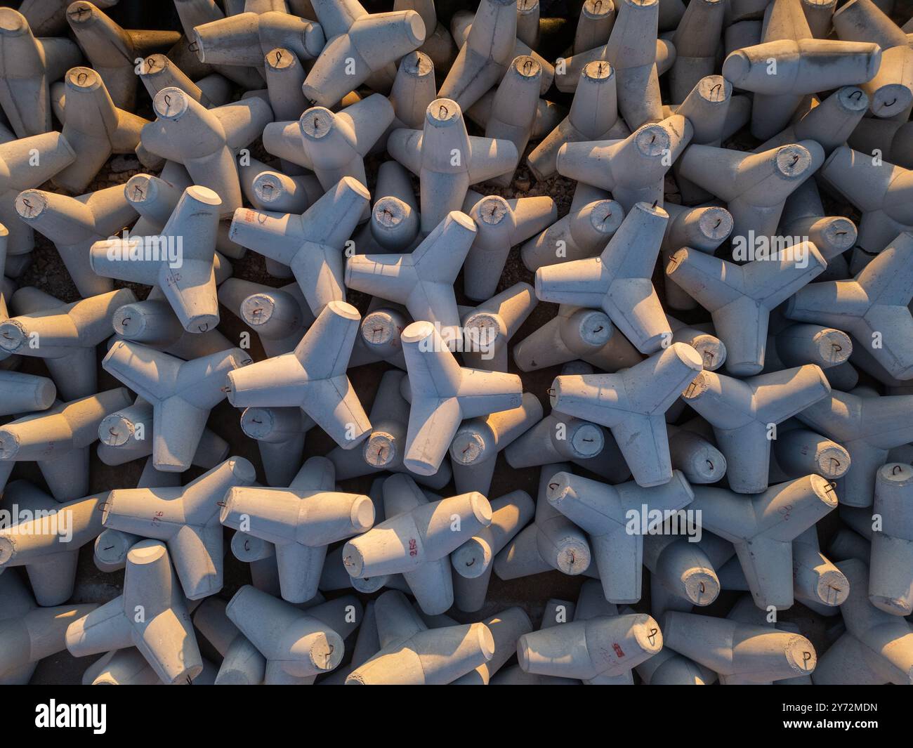 Heavy concrete tetrapods lined along the shoreline at a coastal area ...
