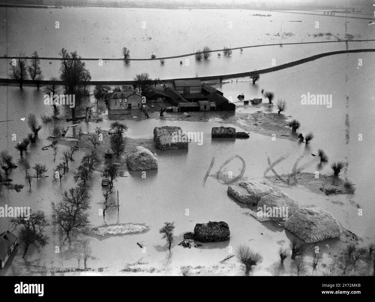 Ruined haystacks stand out in this flooded farmyard scene from their in ...