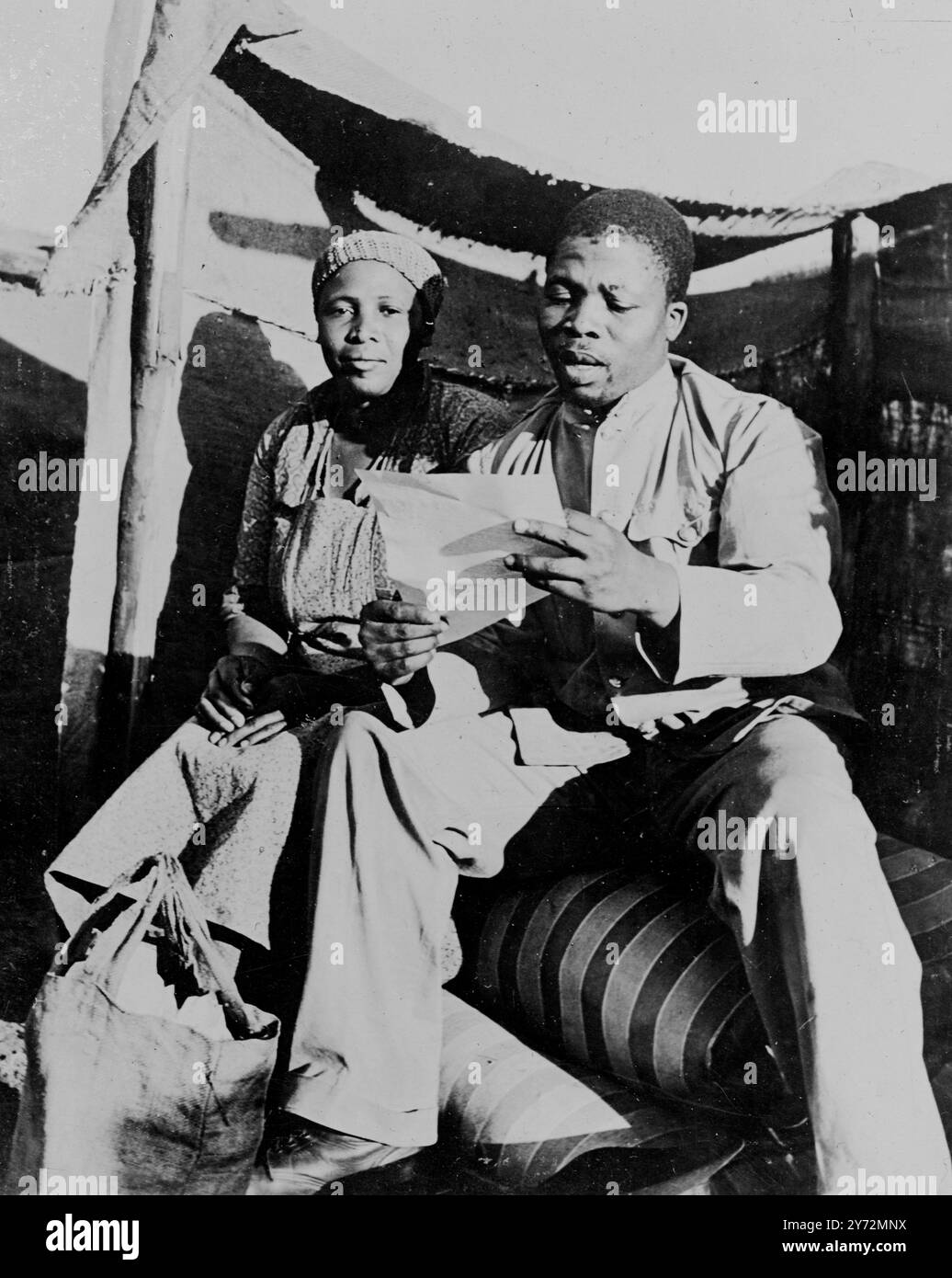 "This is what it says,mother" says the squatter husband as he reads the ...
