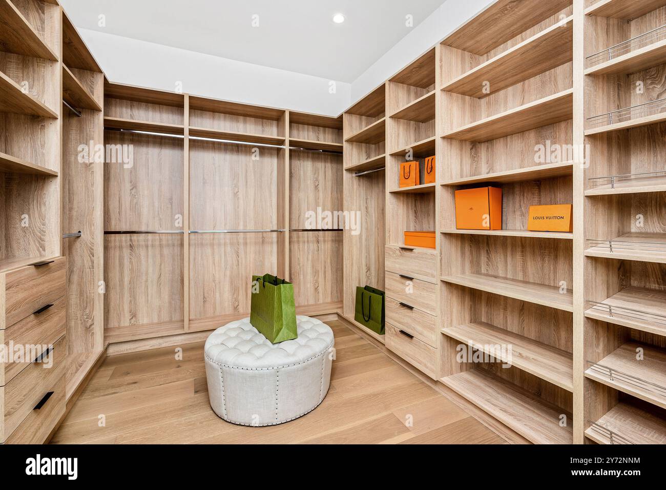 A modern walk-in closet with wooden shelves and drawers, featuring ...