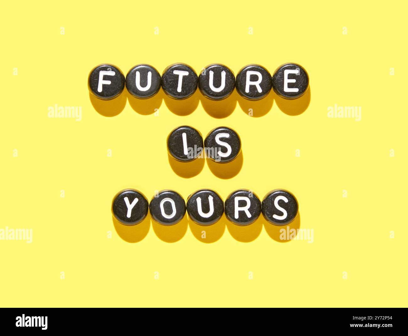 Inspirational alphabet beads on yellow background with future is yours ...