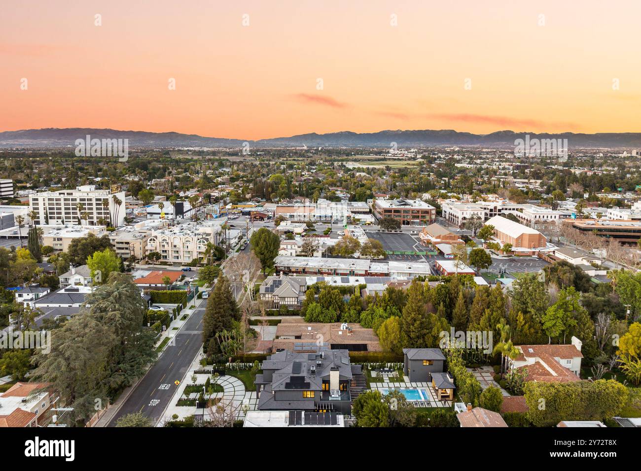 Aerial view of a suburban neighborhood at sunset with a backdrop of ...