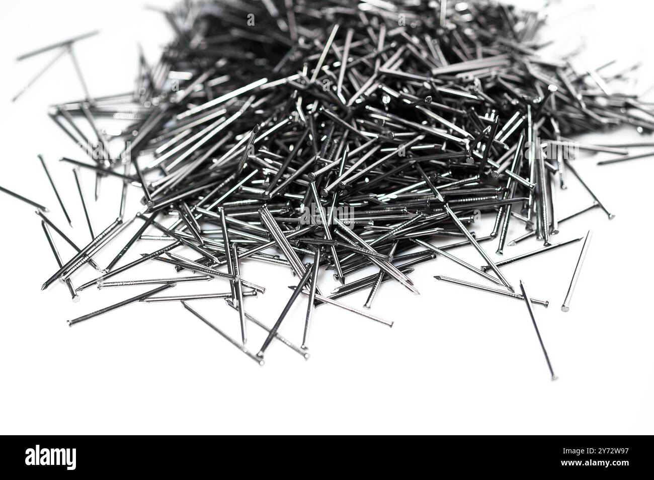 a pile of iron long nails on a white background Stock Photo - Alamy