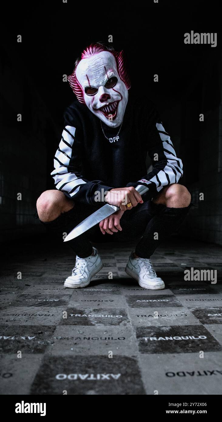 The killer clown. A mysterious masked character in a gloomy abandoned ...
