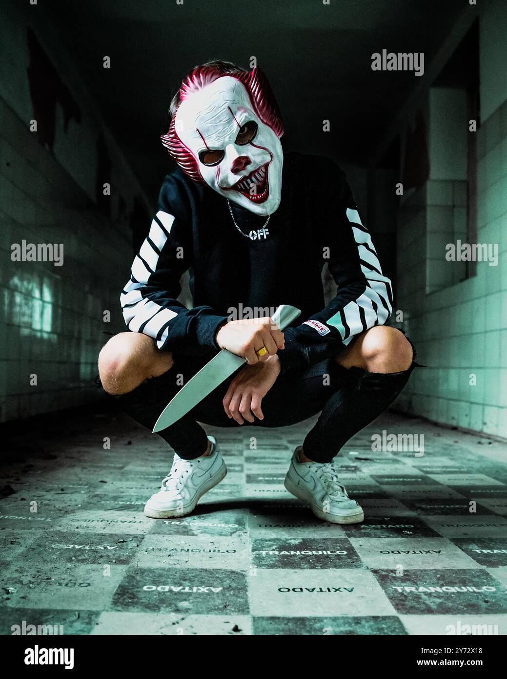 The killer clown. A mysterious masked character in a gloomy abandoned ...