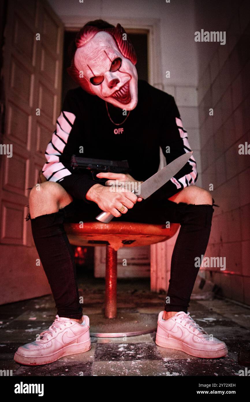 The killer clown. A mysterious masked character in a gloomy abandoned ...
