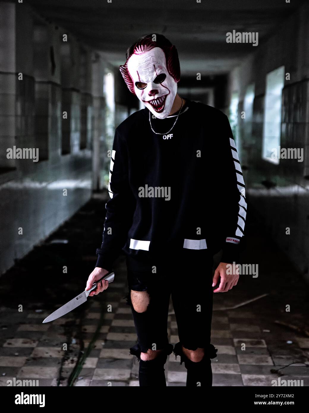 The killer clown. A mysterious masked character in a gloomy abandoned ...