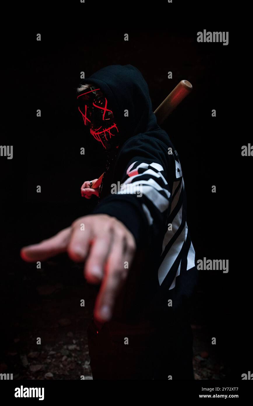 A creepy masked character of the purge anarchy with a baseball bat ...