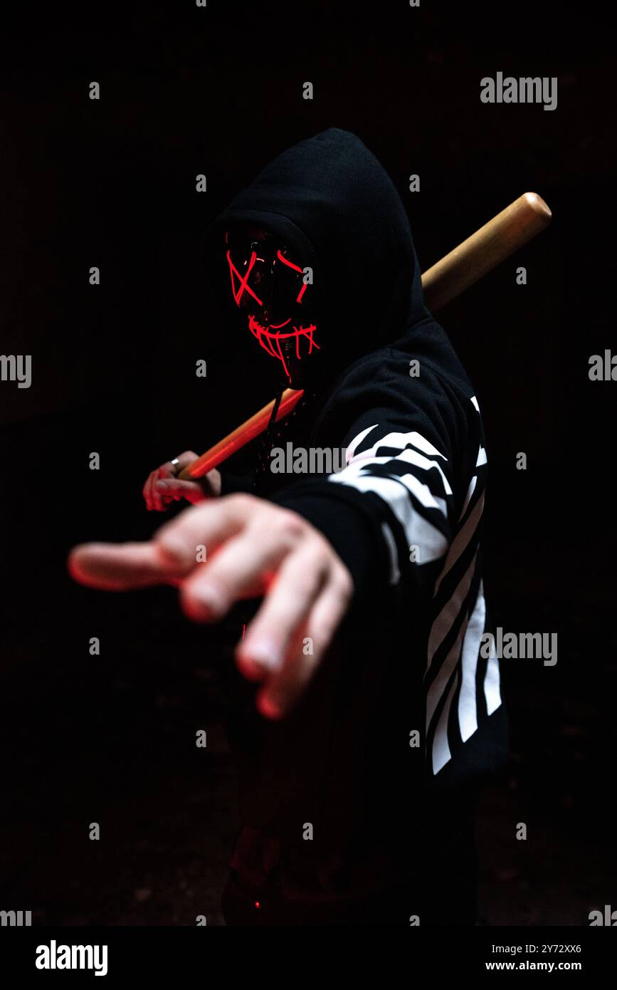 A creepy masked character of the purge anarchy with a baseball bat ...