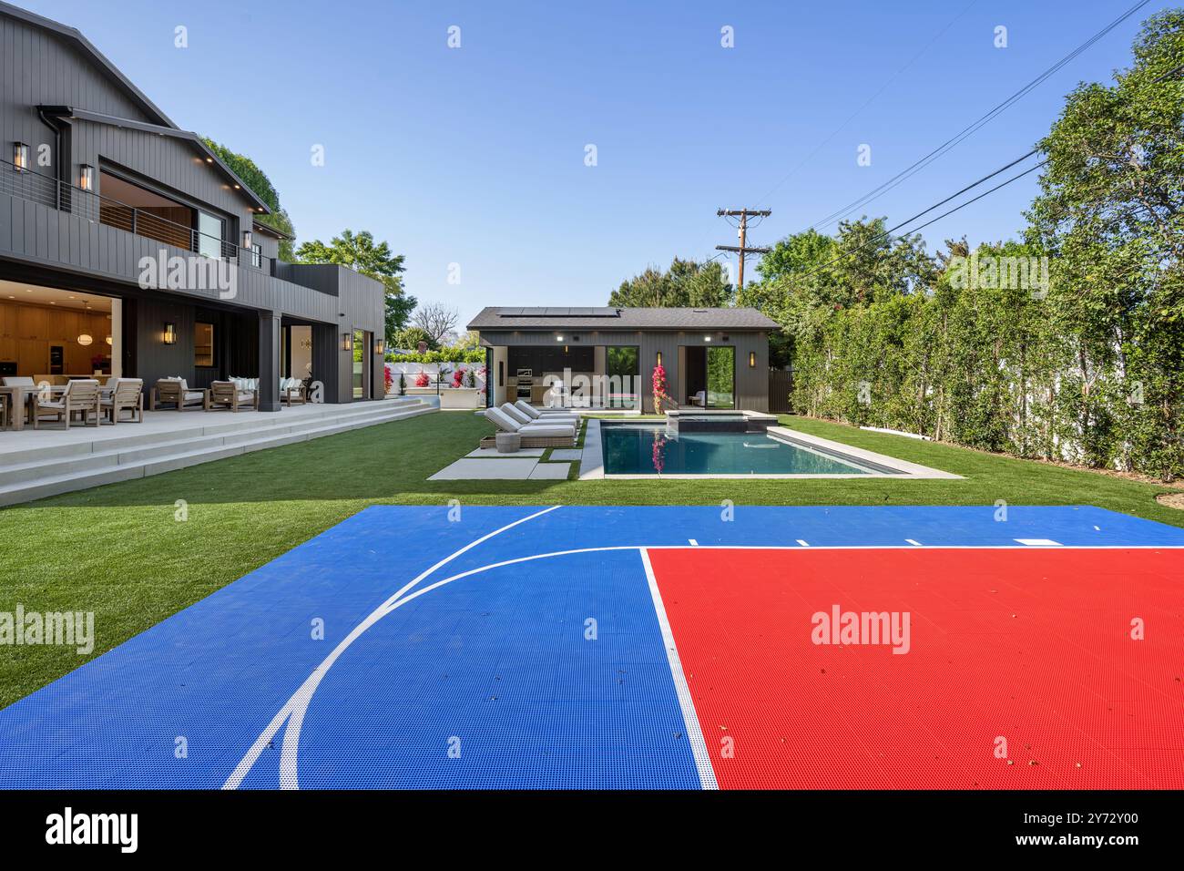 Modern backyard with a basketball court, swimming pool, and patio area ...