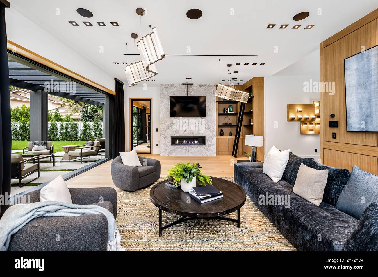 Modern living room with stylish furniture, open sliding doors to patio ...