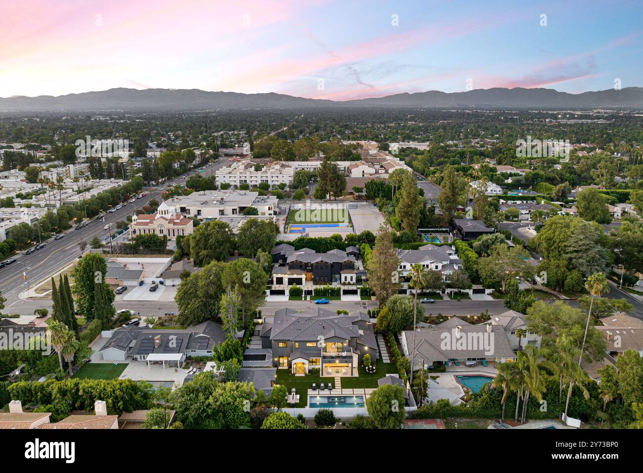 Aerial view of a suburban neighborhood with houses, trees, and distant ...