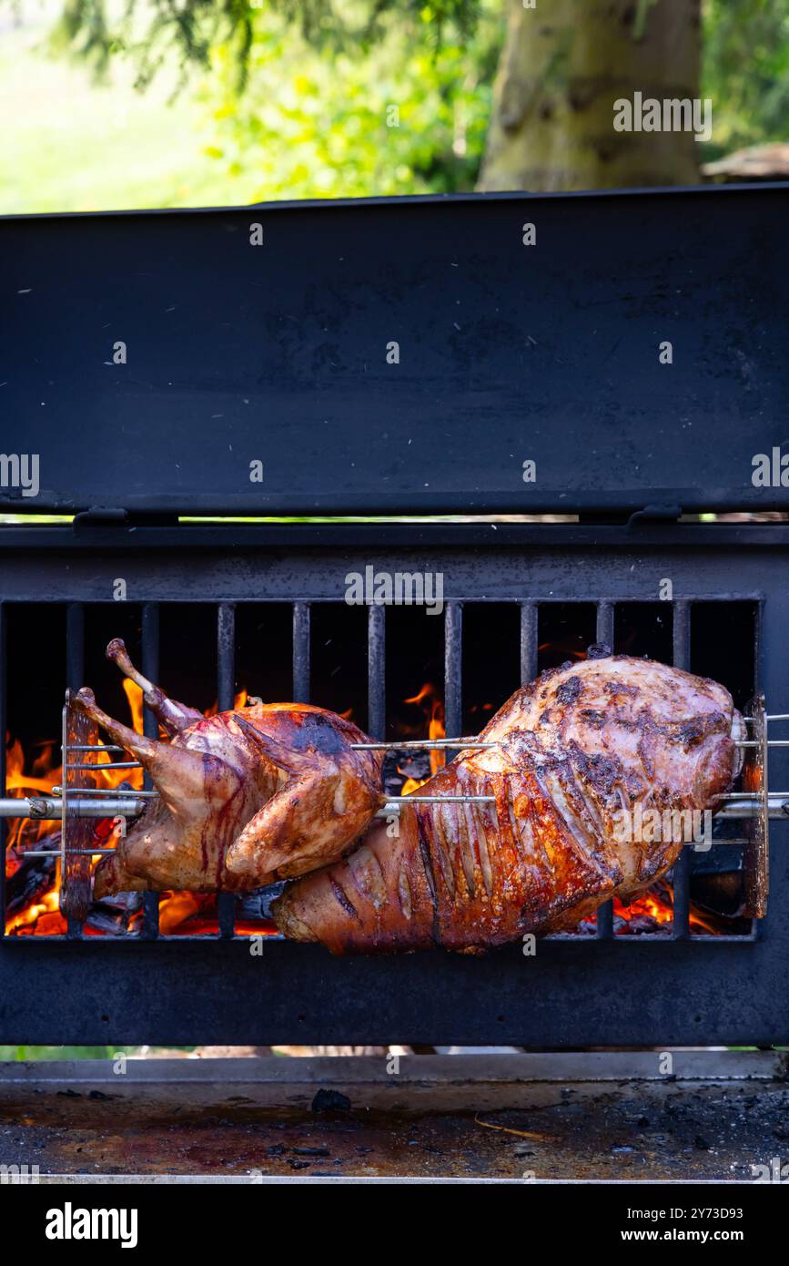 Roasting pork and turkey on spit Stock Photo - Alamy