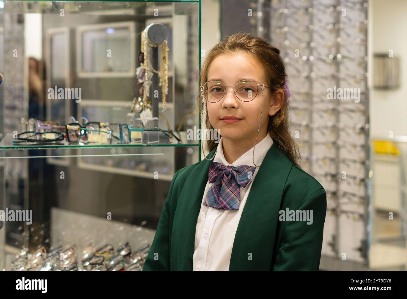 Girl in a school uniform standing confidently inside an optical shop ...