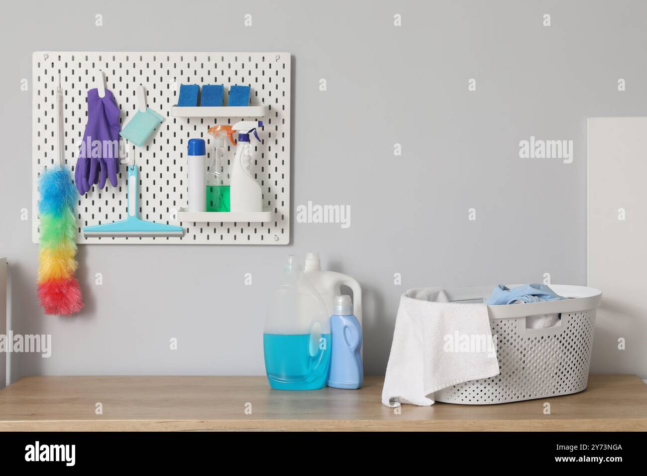 Pegboard with cleaning supplies on light wall in laundry room Stock ...