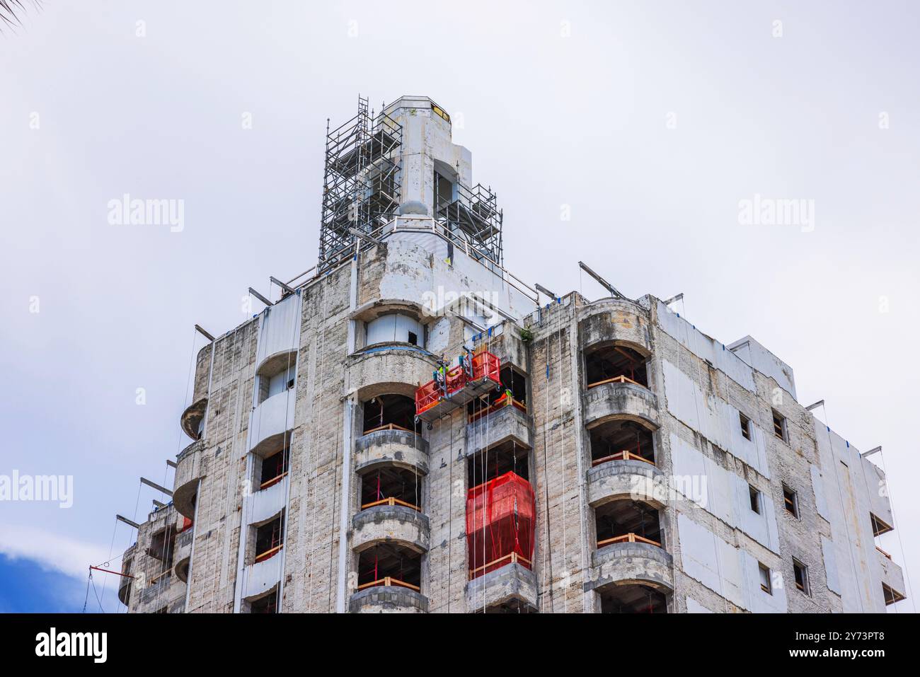 Renovation work on high-rise building with construction workers on ...