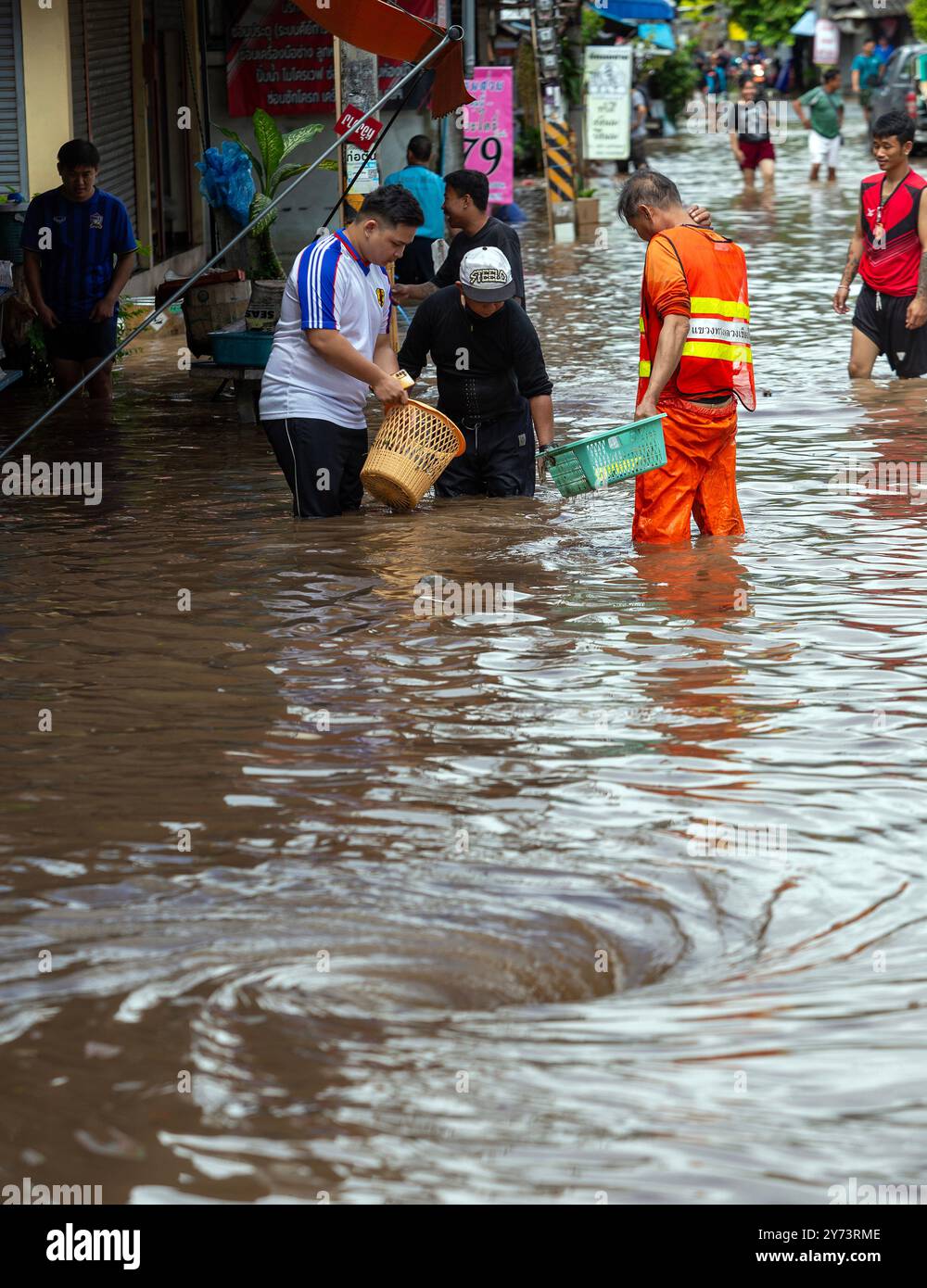 Residents and a Department of Highways worker help clear debris from a ...