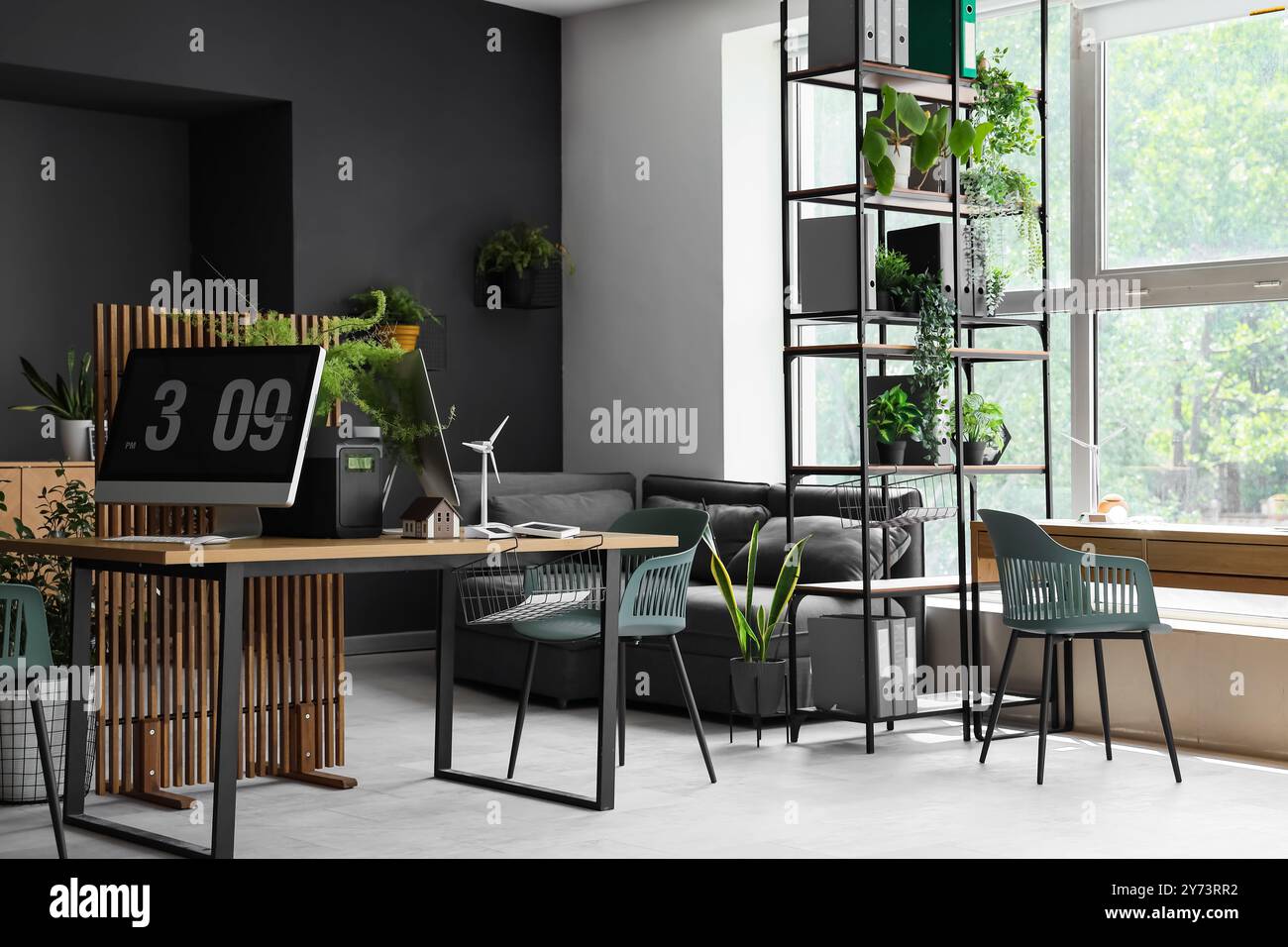 Interior of engineer's office with desks, wind turbine models and ...